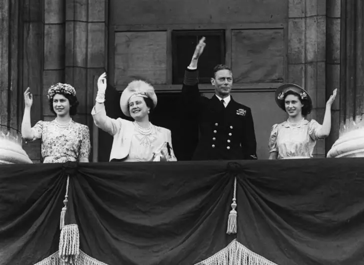 Kuchokera kumanzere kupita kumanja, Mfumukazi Elizabeti, Mfumukazi Elizabeti, Mfumu George VI, ndi Mfumukazi Margaret Rose akugwedeza pakhonde la Buckingham Palace August 15, 1945 pa VJ Day ku London, England.