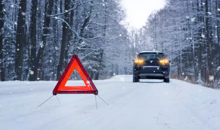 Auto sul lato della strada con neve