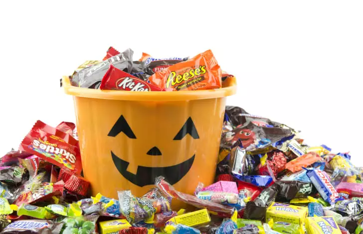 An osan pail pẹlu kún pẹlu, ati ti yika nipasẹ, Halloween candy.