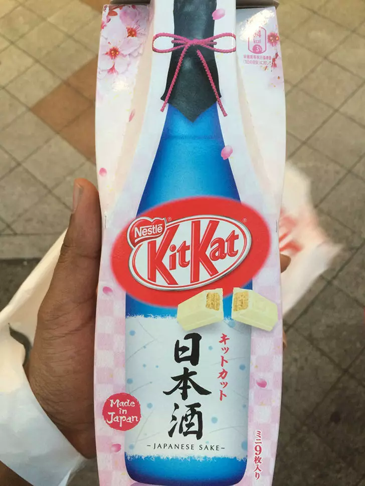 Persono tenanta pakaĵon da sake-aromitaj kit kats.