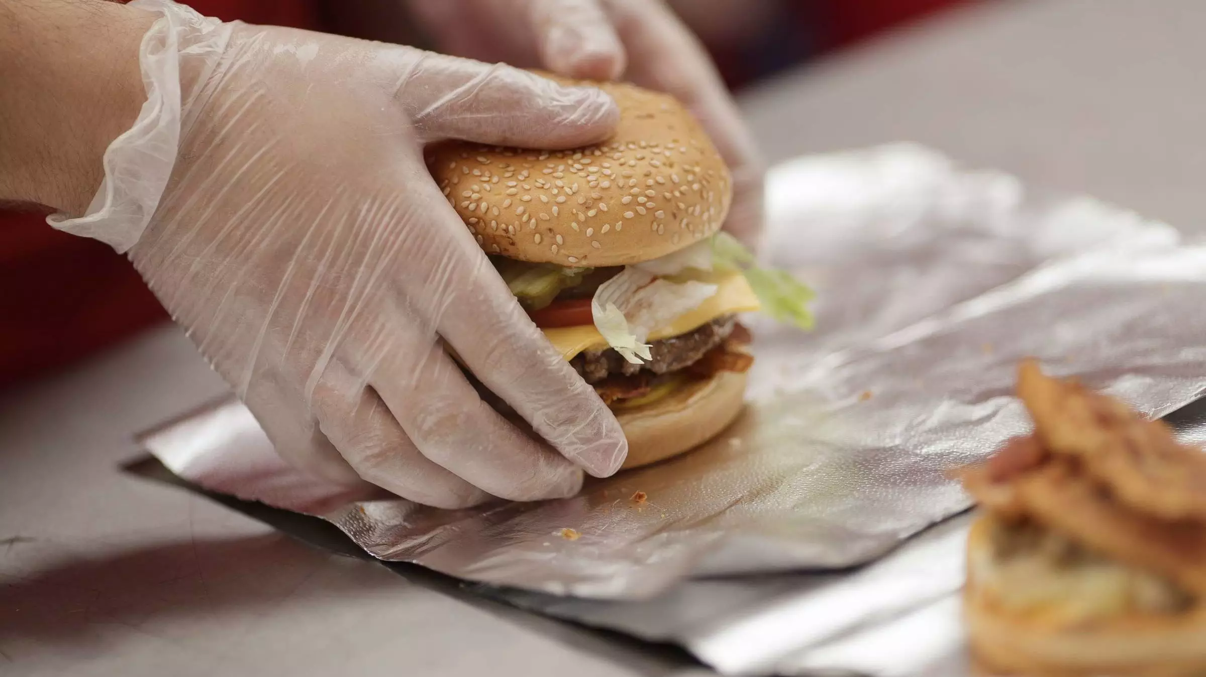 Cinque ragazzi cucinano i loro hamburger ben fatti per un motivo intelligente