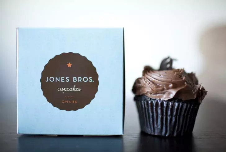 Usa ka Jones Bros Sweet ug Salty nga cupcake sunod sa usa ka kahon.