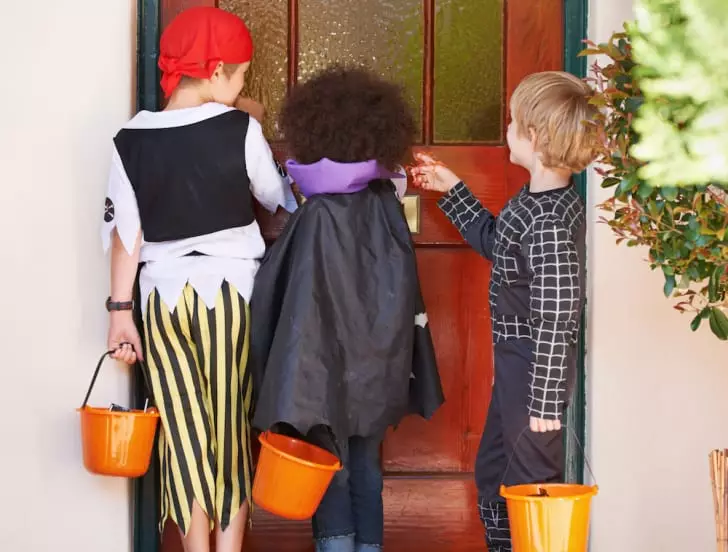 Les enfants frappent à la porte en costume.